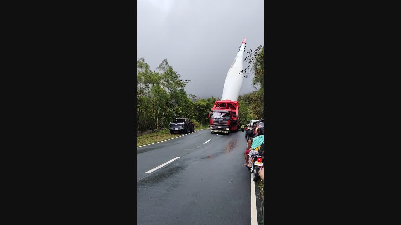 Truck carrying giant windmill blade causes traffic jam