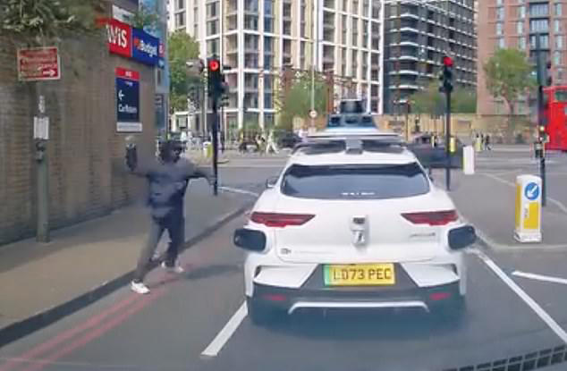 Moment man hurls 'rock' at Waymo multiple times - before 'driverless ...