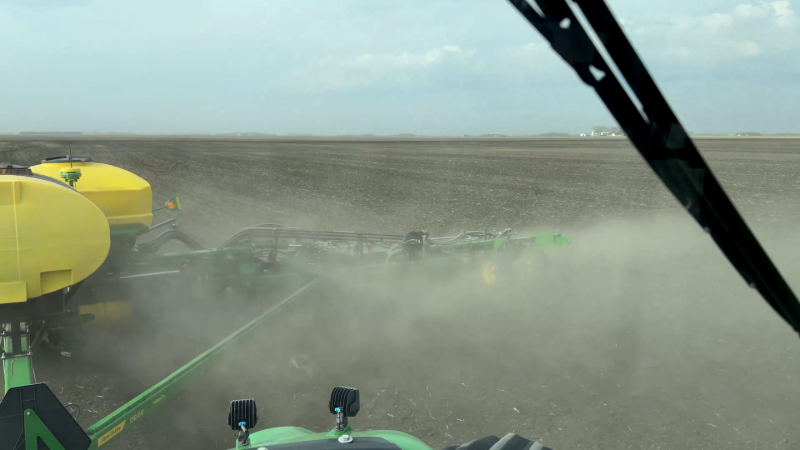 Blowing dust sweeps across fields and roads from Minnesota into Canada
