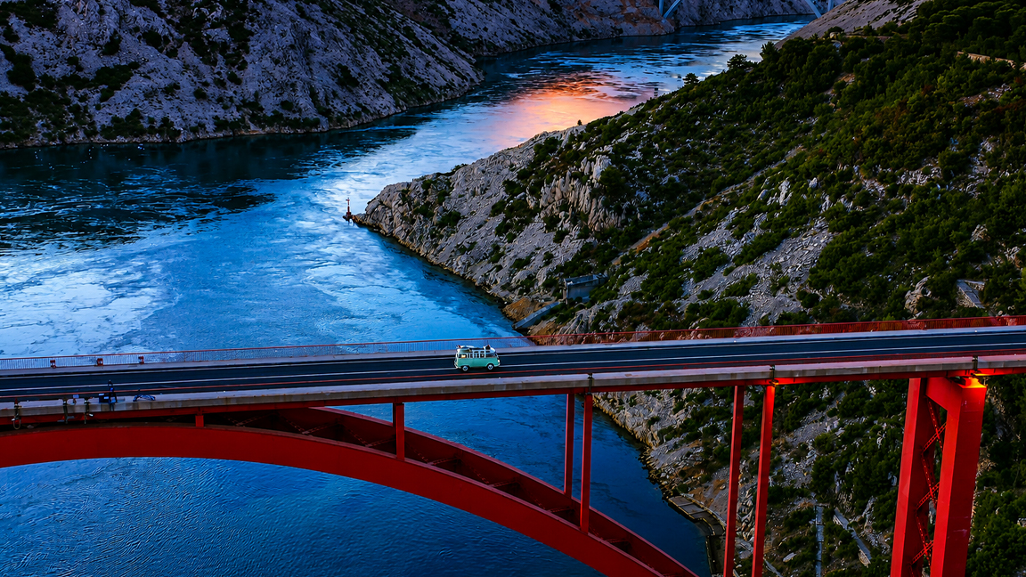 Small van crossing a bridge above the Blue River