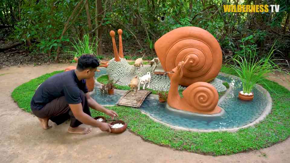 Watch rescued puppies discover their giant clay snail house in the jungle