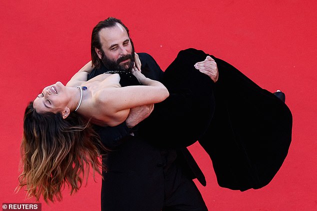 Vincent Macaigne carries model Laetitia Casta along the red carpet amid ...