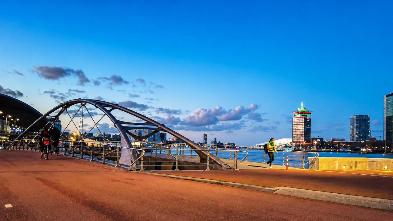 Bersepeda sore di Amsterdam sepanjang pesisir dengan pemandangan skyline