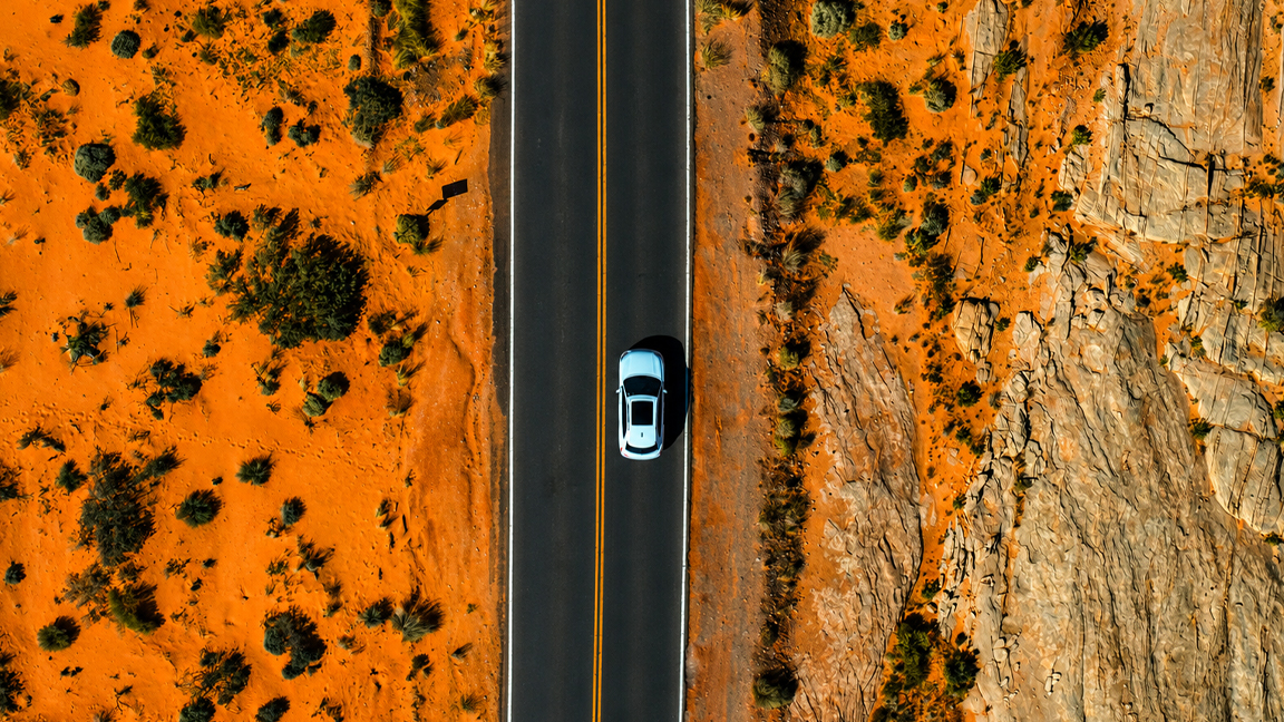 Auto bianca lungo un’autostrada isolata nel deserto