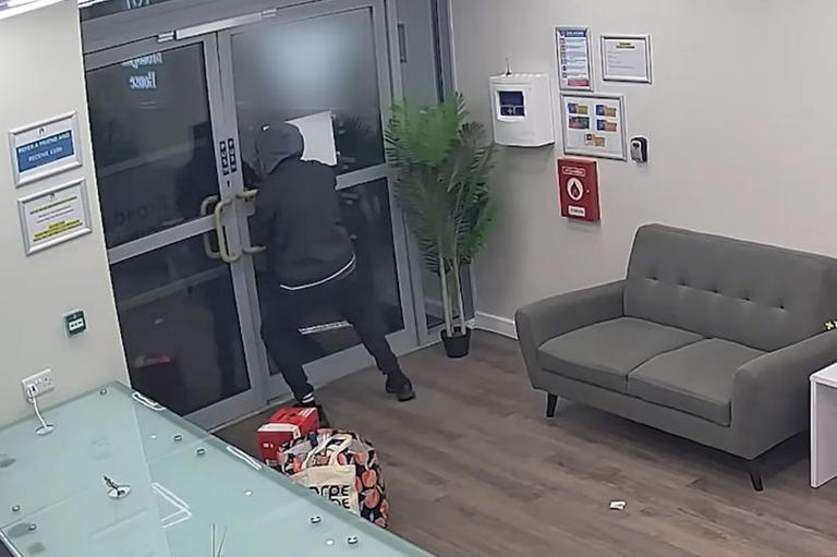 Watch as bungling burglar caught red-handed struggling to open door in ...