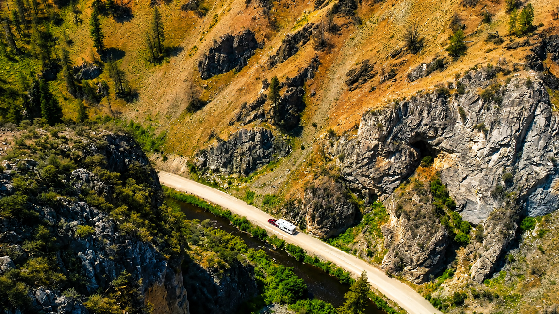 Dramatic canyon landscape with vehicle on mountain road