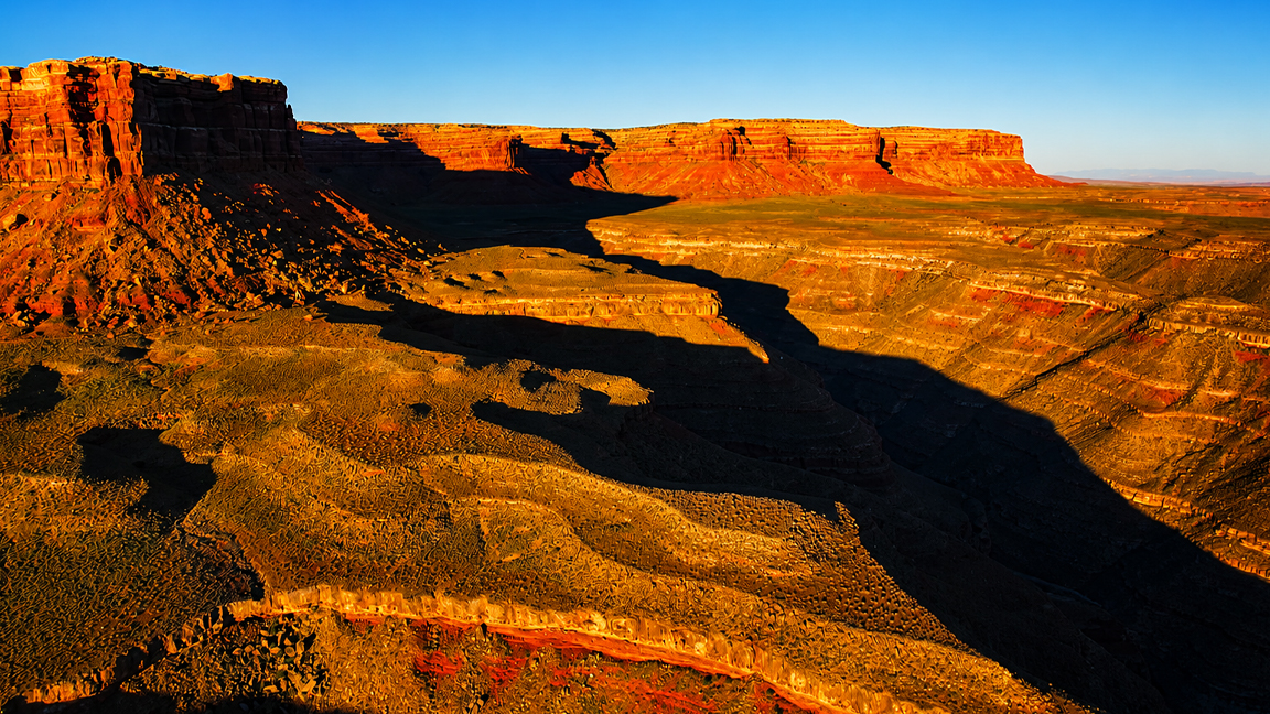 Dramatic red rock cliffs and deep canyon shadows