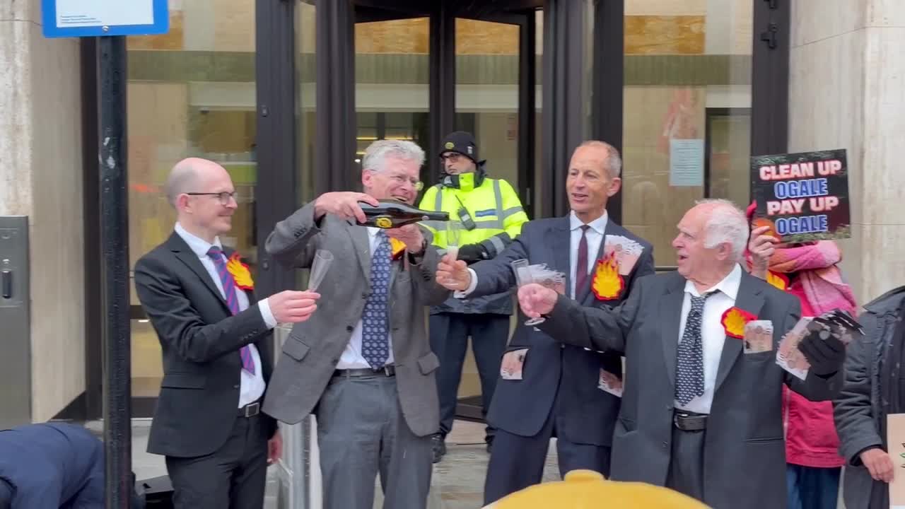 Climate activists dressed as executives drink 'oil' outside Shell HQ on ...