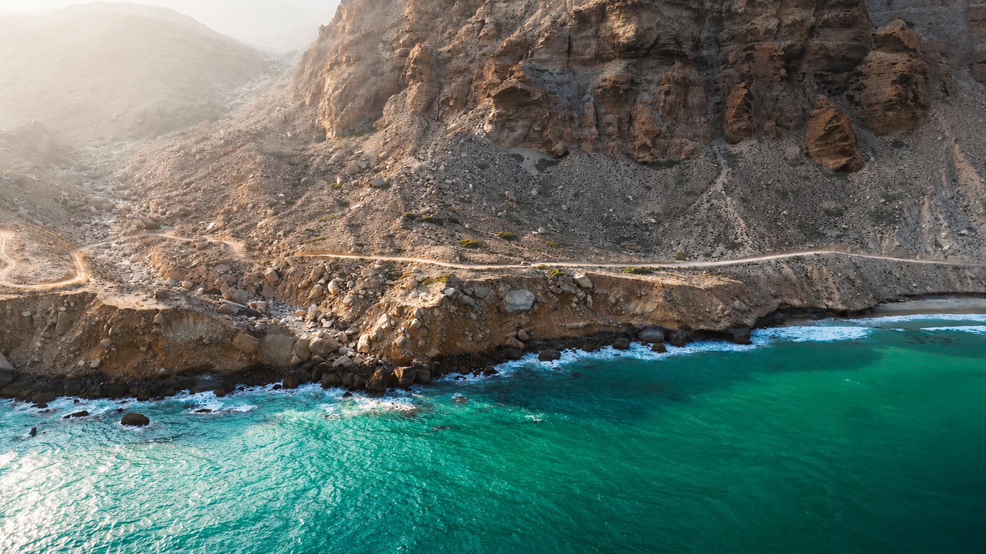 This remote road runs beside empty cliffs