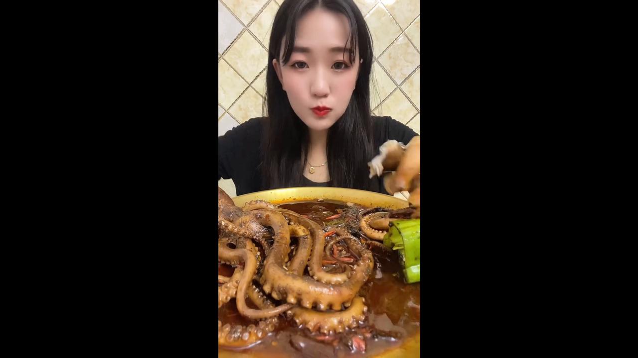 Mukbang eating tender baby octopus with deep red seafood soup delight