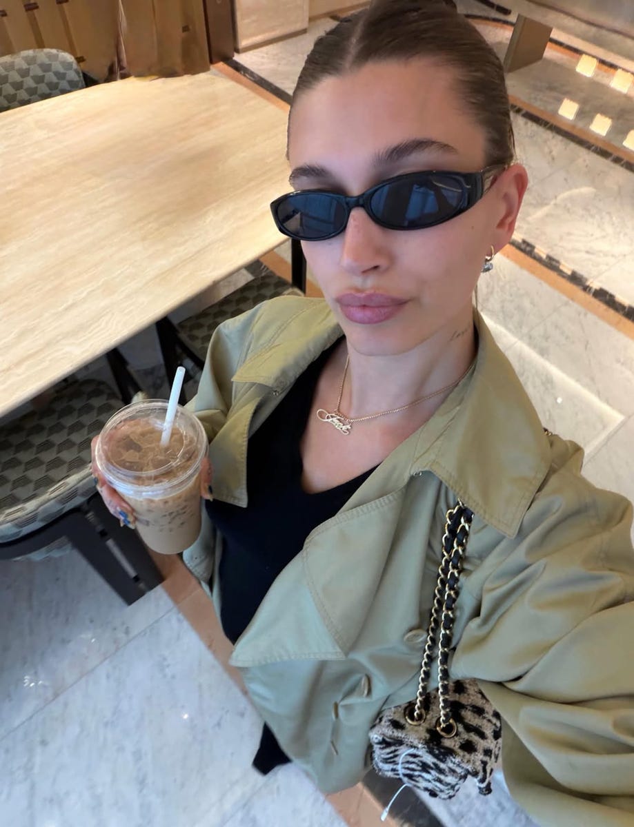 Hailey Bieber wears a sheer lace shirt and black pants for a grocery run