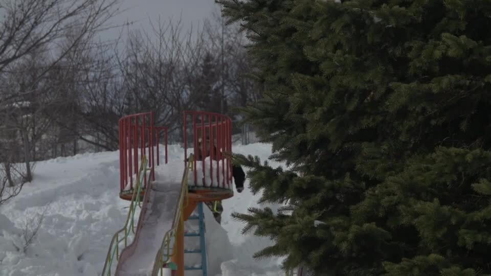 Skier rides down a playground slide