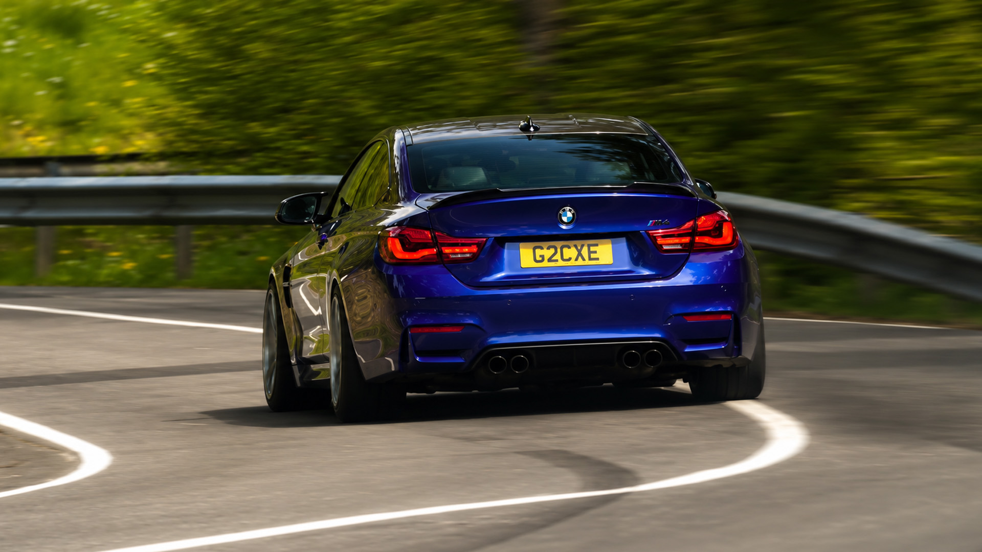 BMW M4 pushes hard through downhill road
