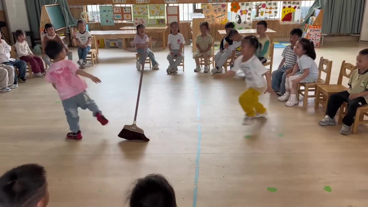 Preschoolers play 'don't drop the broom' game in fun classroom activity