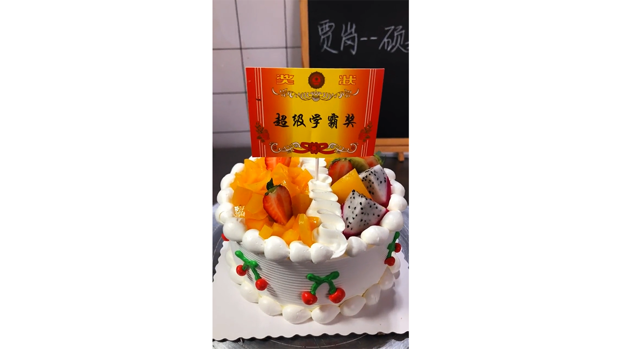 Decorating white cream cake with graduation award topper and fresh ...