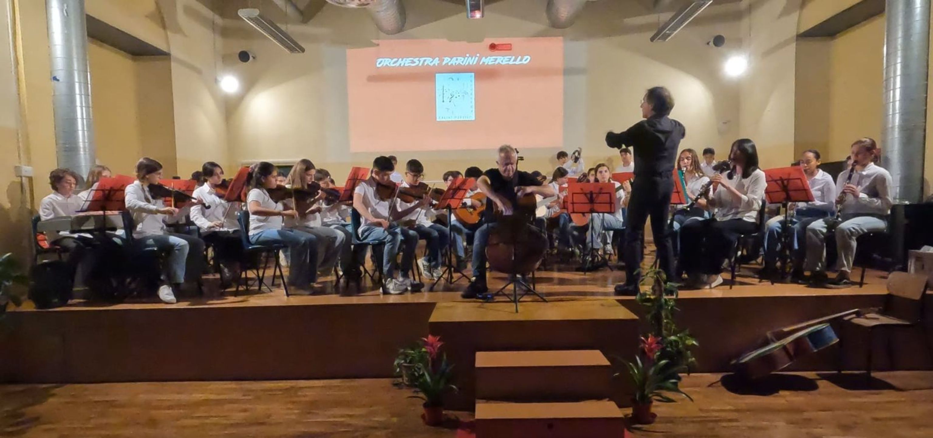 Giovanni Sollima suona con un'orchestra di ragazzini in una scuola genovese
