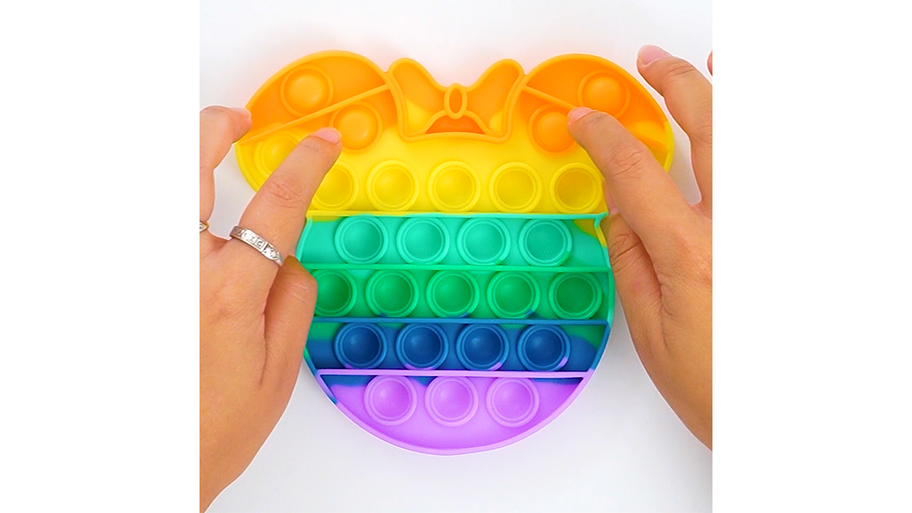 Pressing a rainbow Minnie Mouse pop it with smooth bubble texture