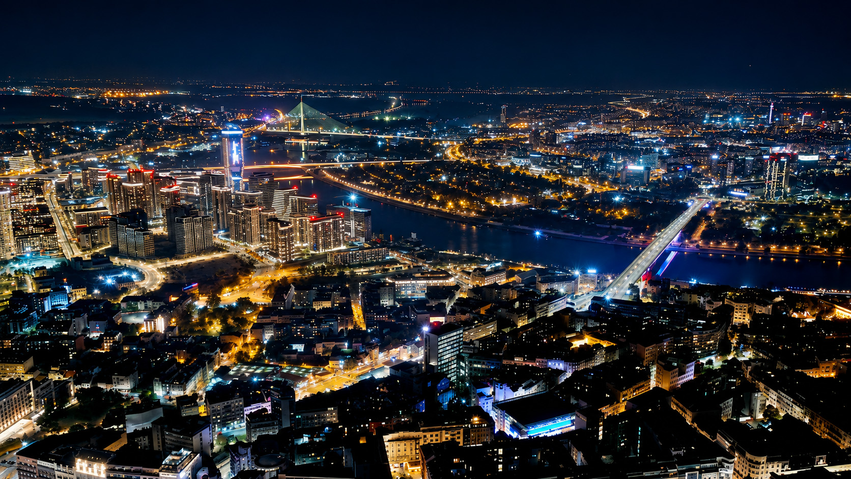 A river city skyline glowing across the night