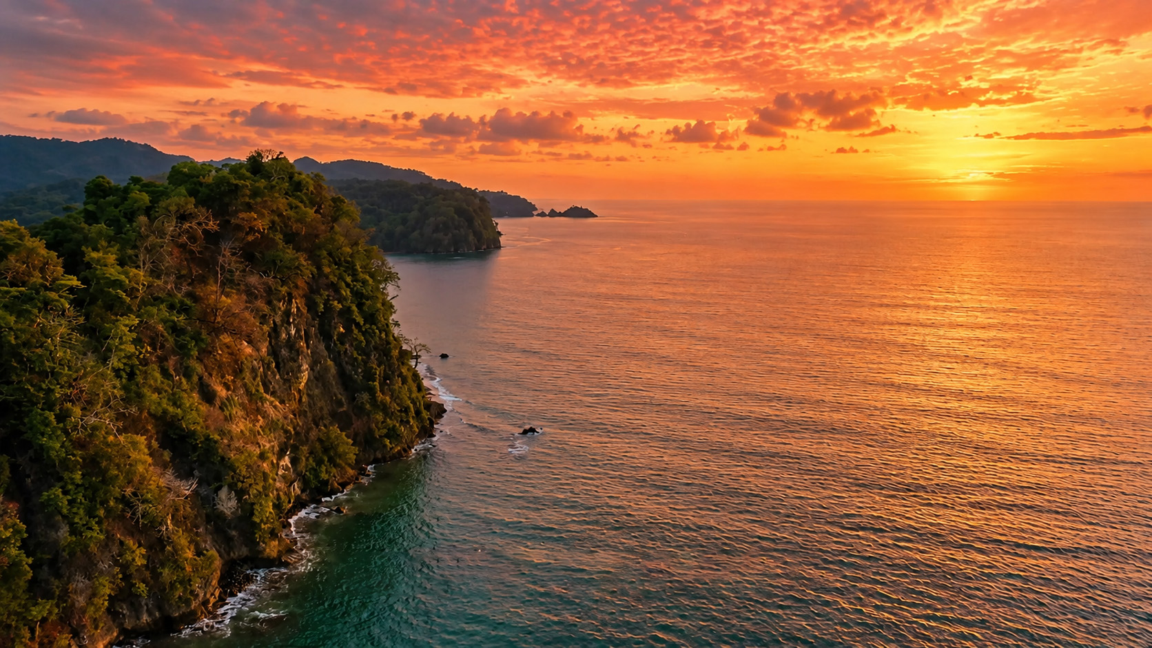 A remote tropical coastline glowing under the sunset sky
