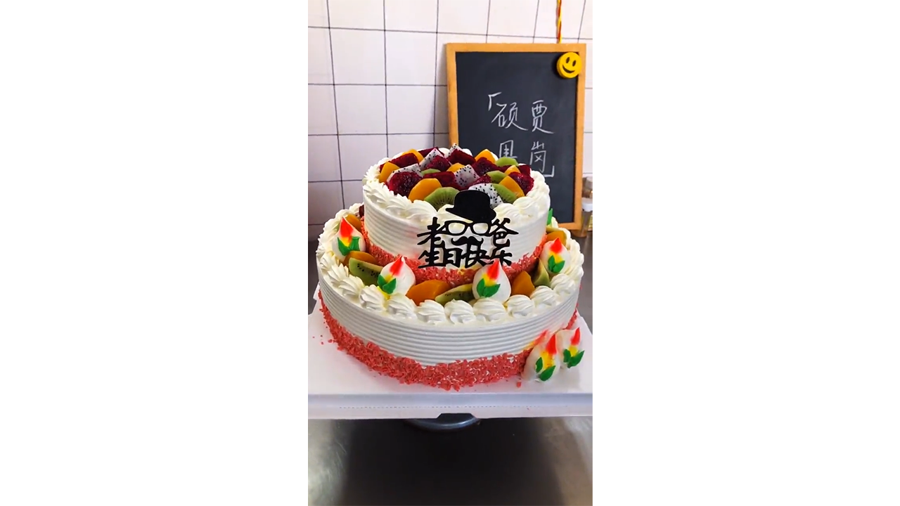 Decorating two tier white cream cake with fresh fruit toppings creating ...