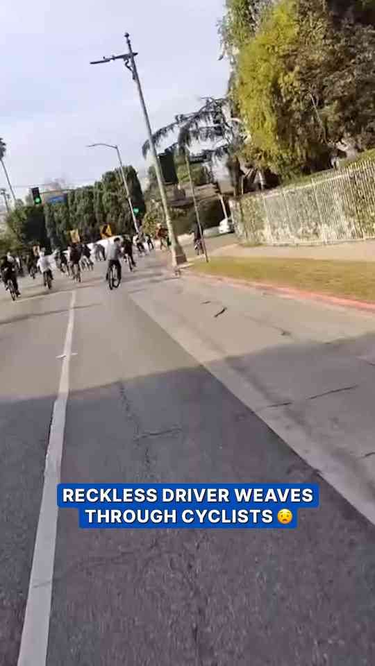 Driver dangerously weaves through group of cyclists on busy road