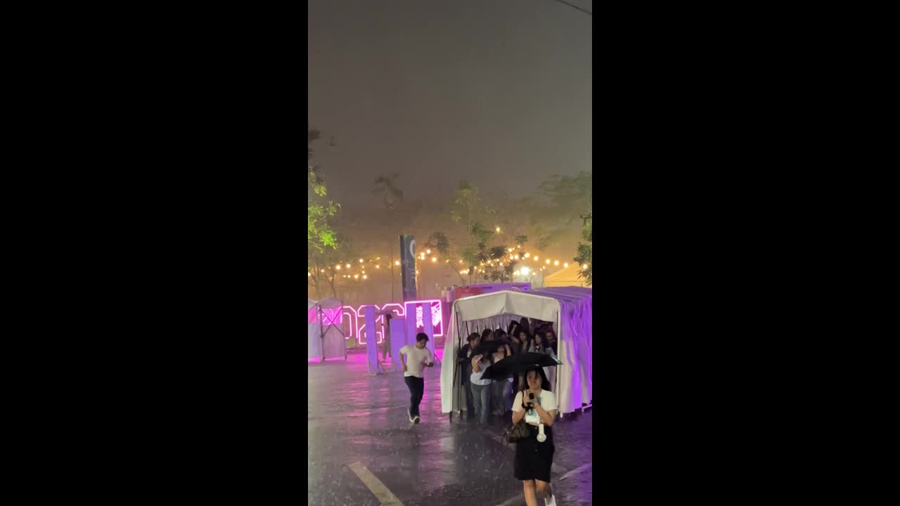 Crowd carries tents to take cover from the rain