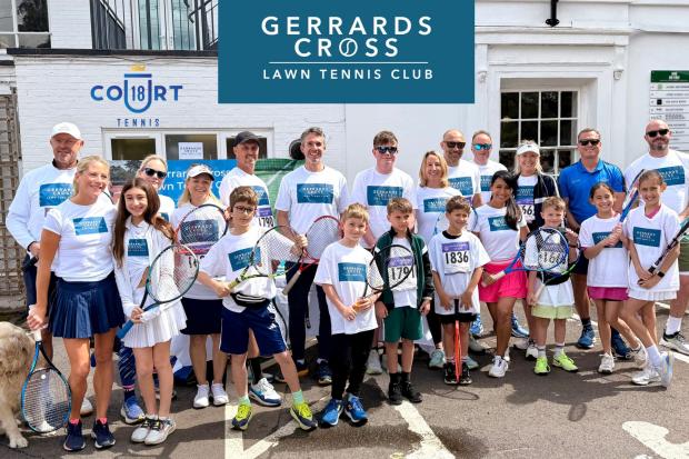 Tennis club takes part in fun run carrying rackets