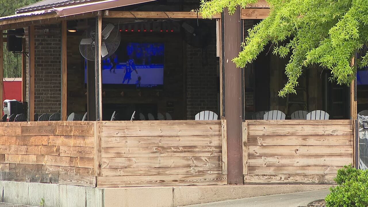 Man sitting on restaurant patio shot in neck
