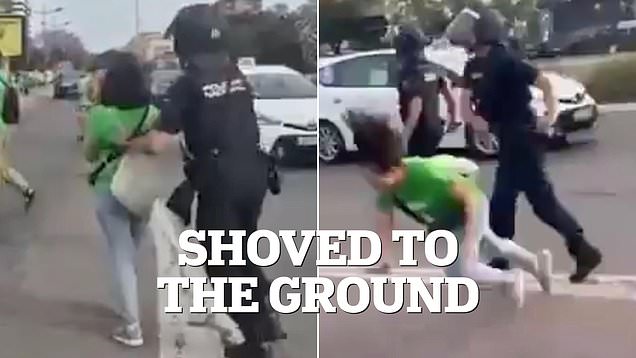 Shocking moment riot police officer shoves woman to the ground