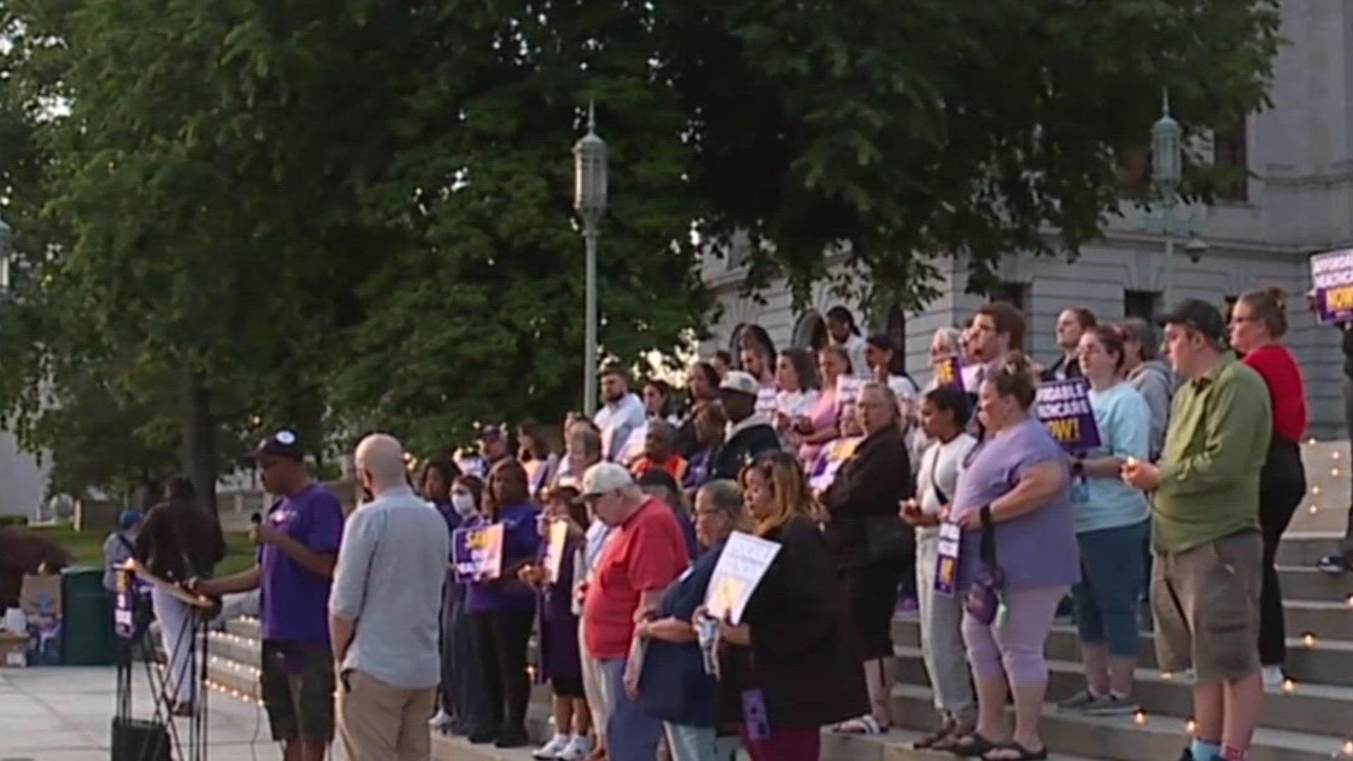 Healthcare workers gather at Capitol, light candles to protest federal ...