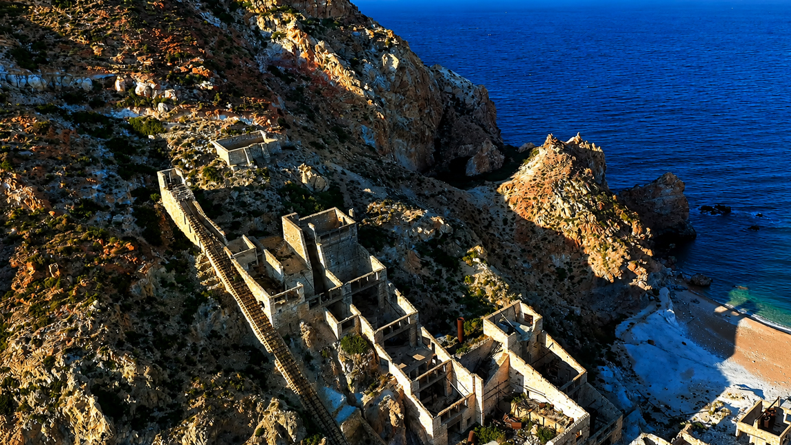 Abandoned coastal ruins on a rocky cliff overlooking the deep blue sea