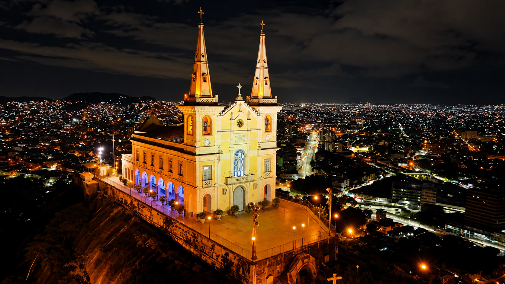 Una iglesia iluminada en la colina sobre Medellín de noche