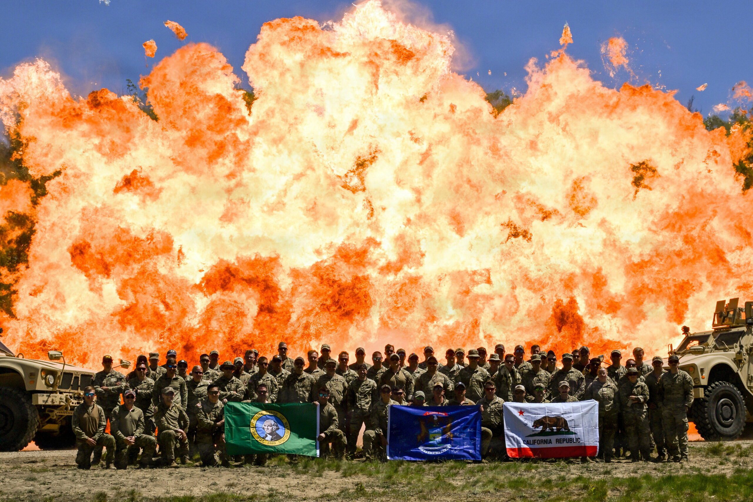 Bomb squad soldiers pose in front of huge blast during training