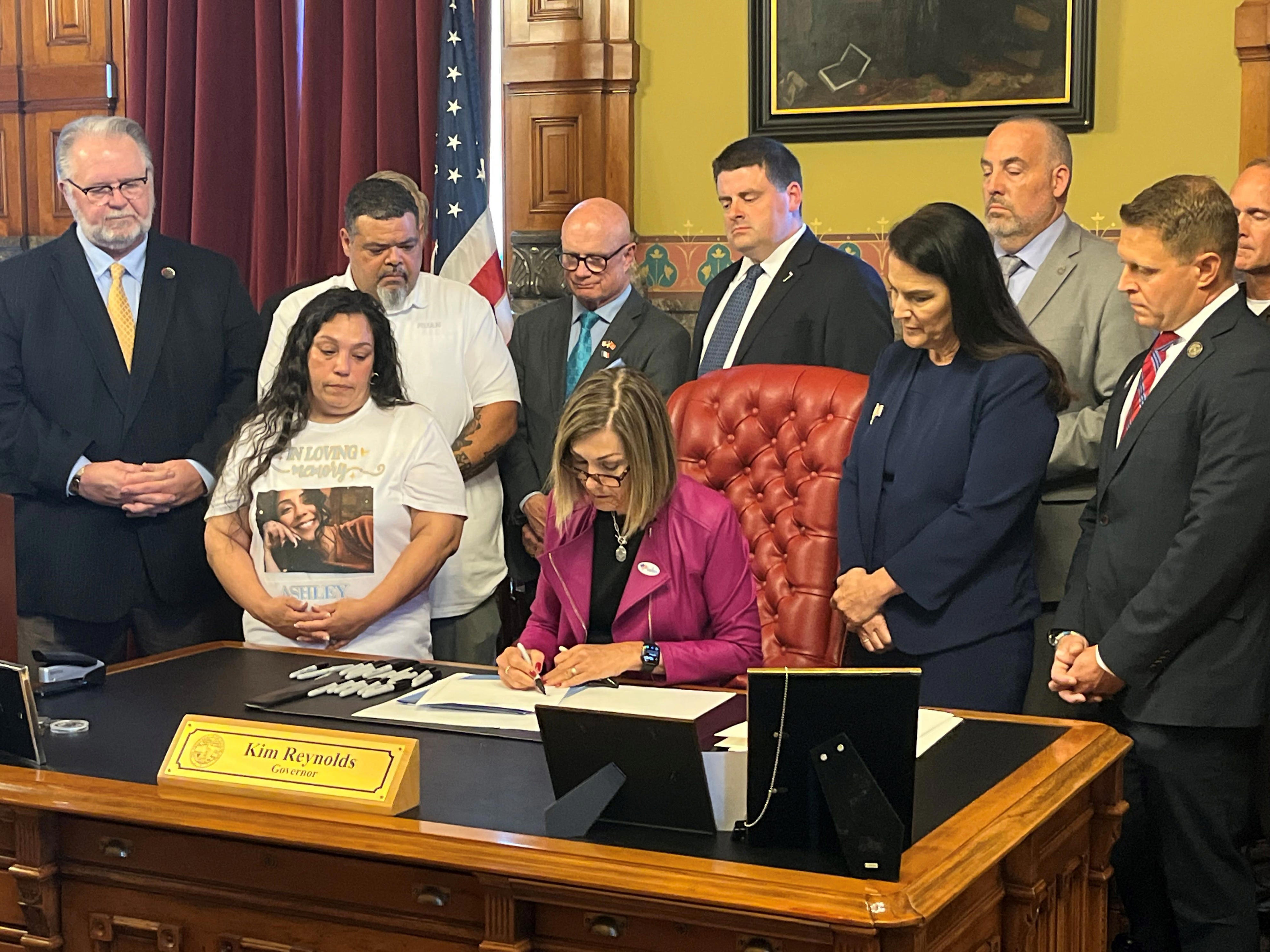Kim Reynolds signs 3-strikes law as Iowa prisons near capacity