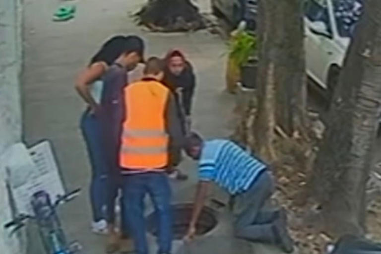 Woman rushed to hospital after falling down manhole when men 'tried to ...