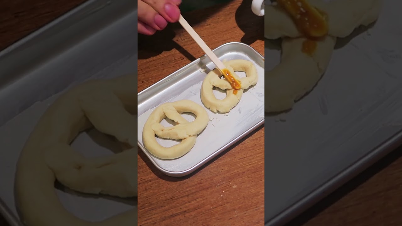 Amateur baker builds fresh salty pretzels using toy oven mixes