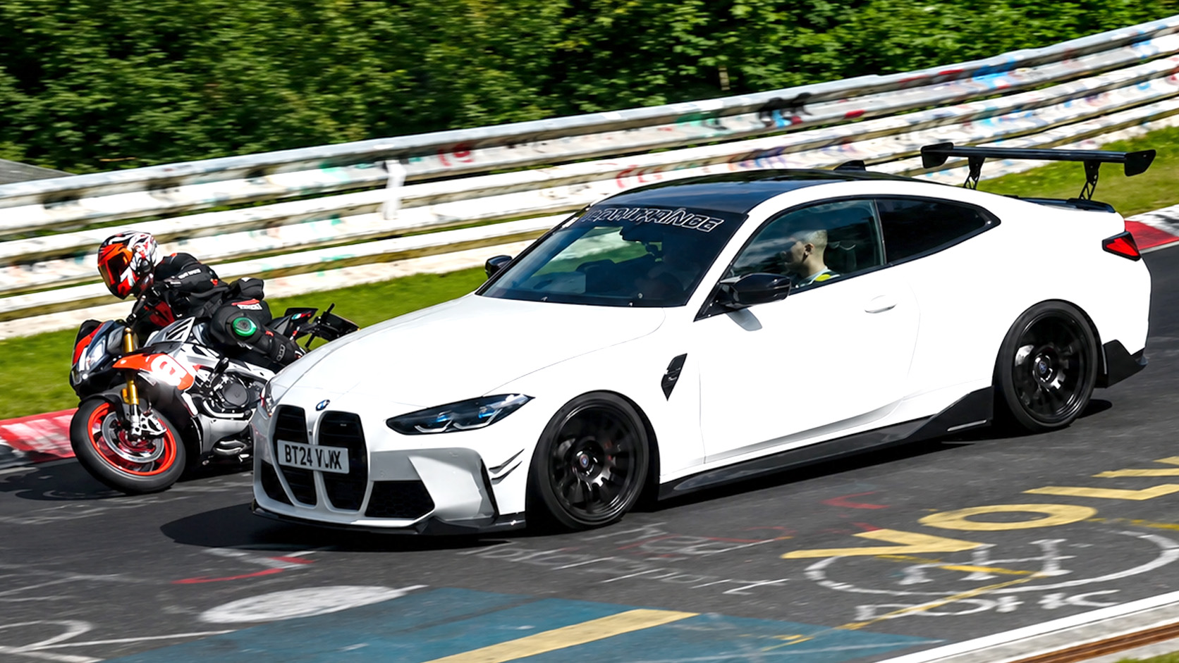 BMW and motorbike get too close during a risky mid-corner overtake