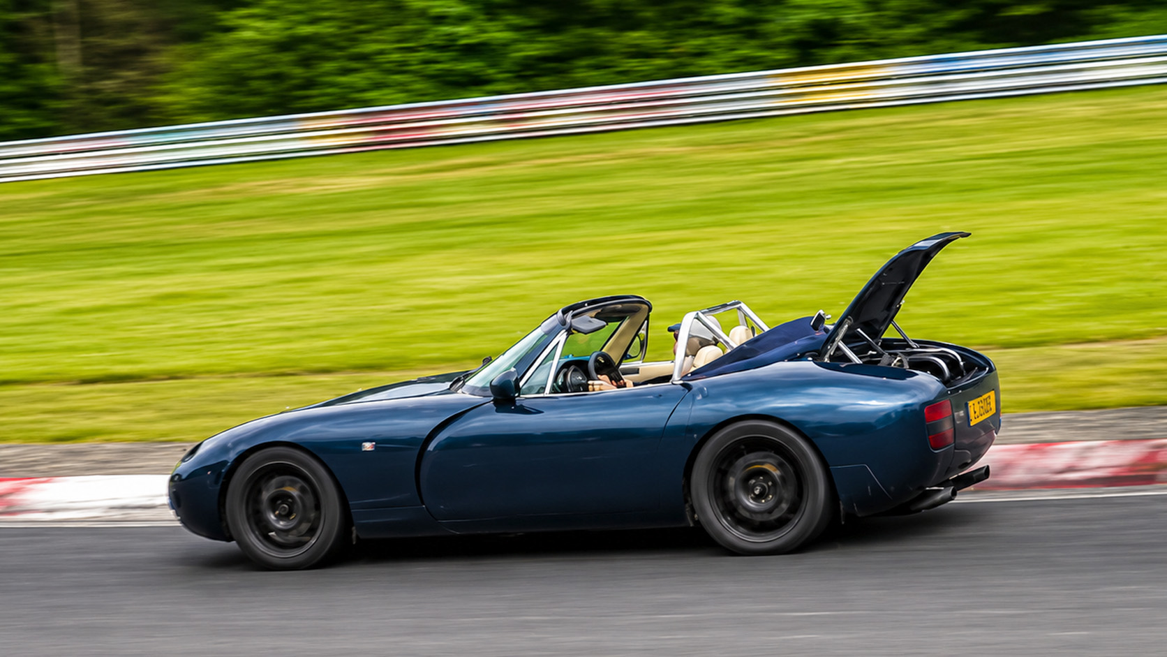 Convertible car caught on track with its rear trunk open