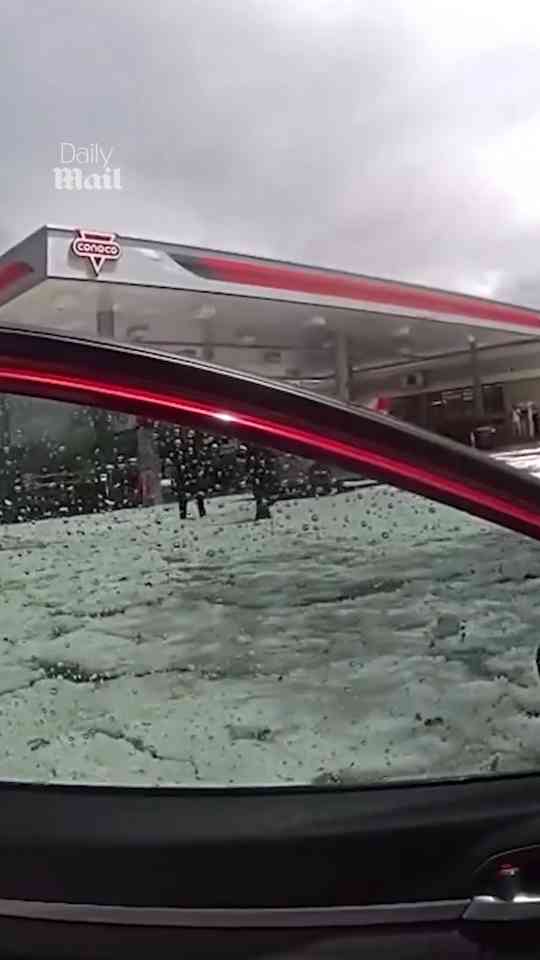 Police officer wades through deep floodwaters to rescue stranded driver