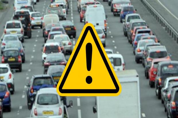 Broken down vehicle blocks lane on M6 roundabout with traffic moving slowly