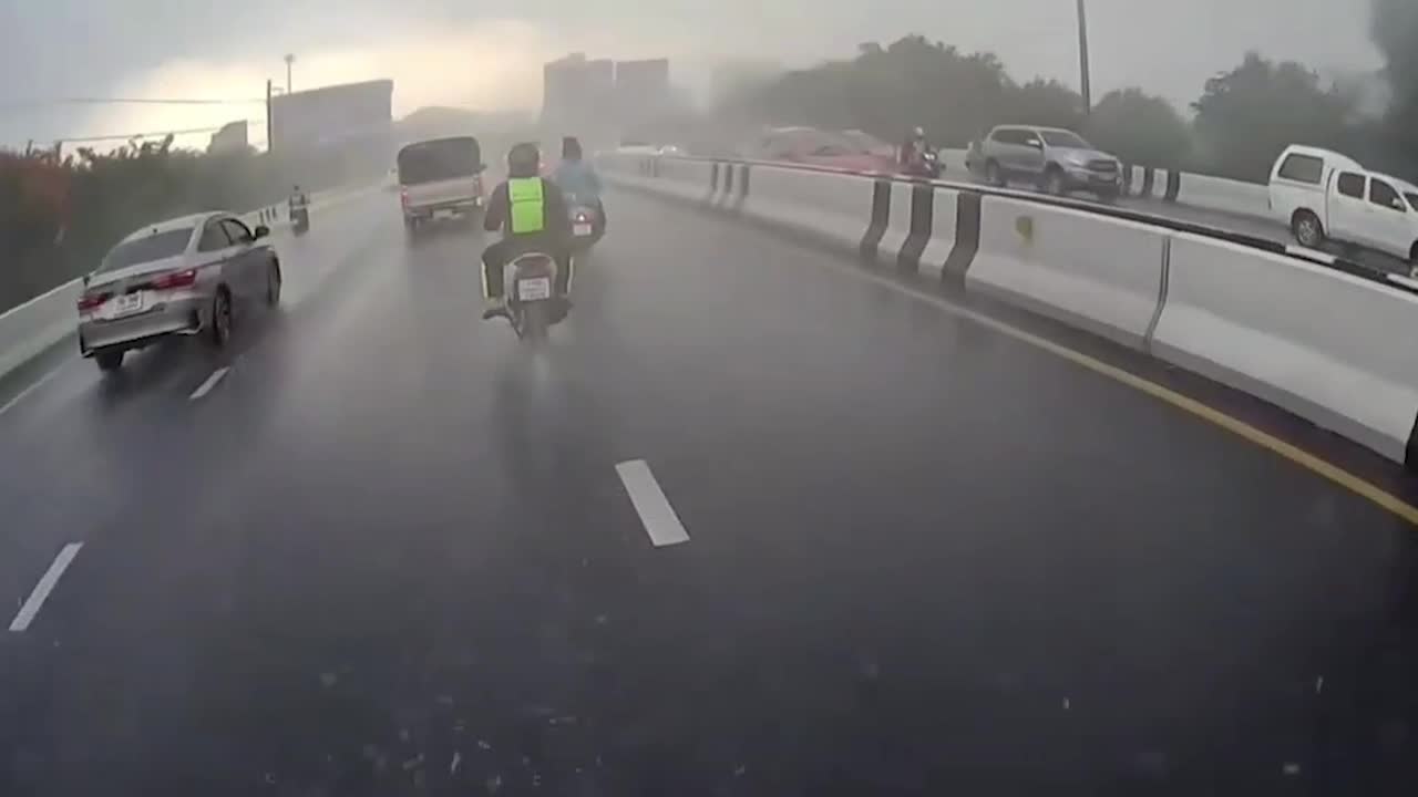 Lightning strikes motorcycle rider on busy road during storm