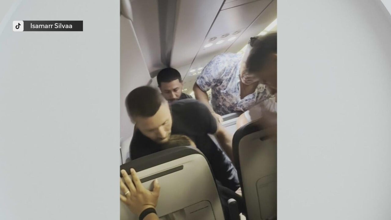 Video shows passengers detaining man accused of trying to open plane ...