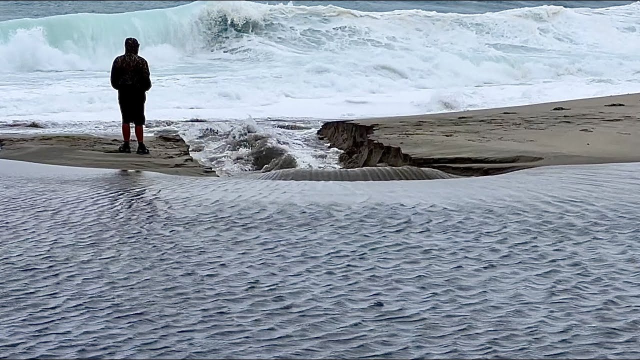 Heavy rain leads to river breaching sand berm