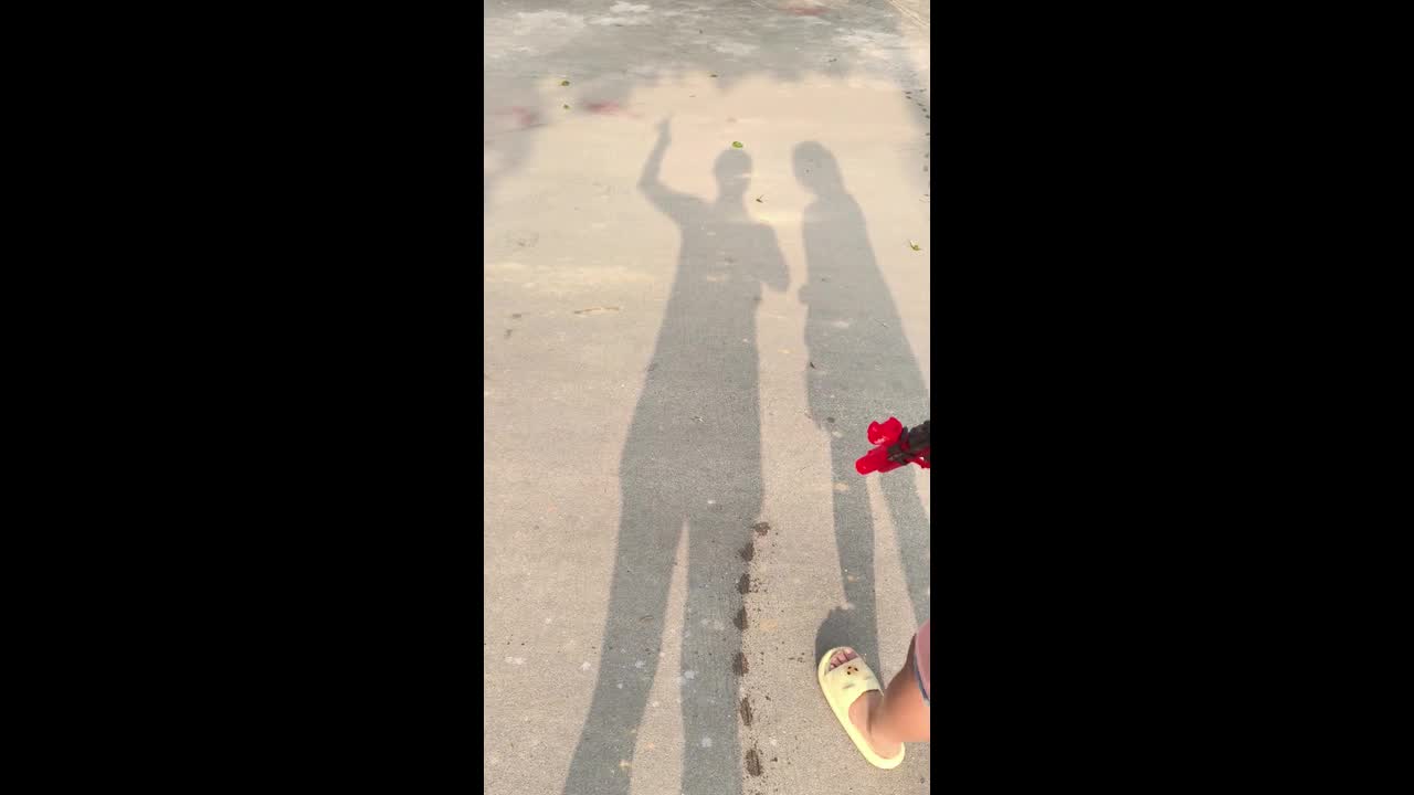 Child traces shadow with water gun in Guangdong, China
