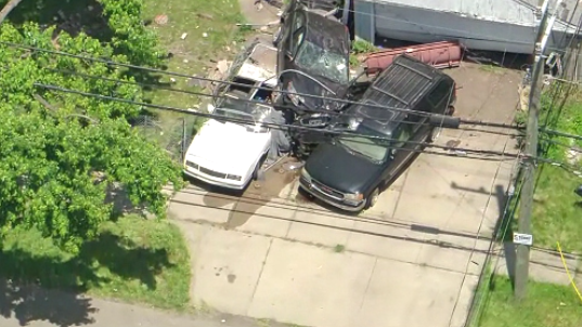 Driver critically injured after car lands on vehicles, fence pole ...