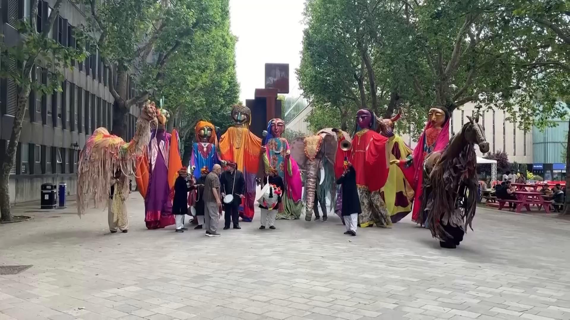 Ten 12 ft puppets parade down London street