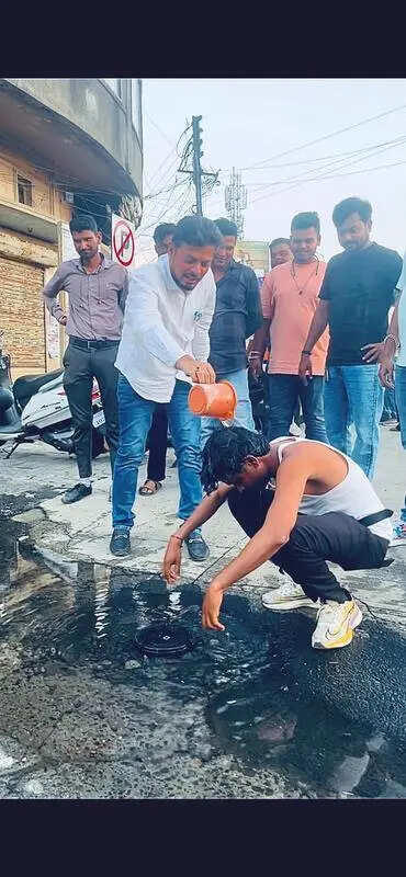 Corporator bathes in puddle to protest water wastage due to leaking ...