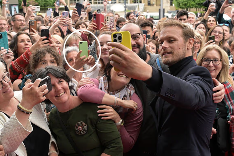 Moment swooning Edinburgh tourist poses with Sam Heughan on world ...