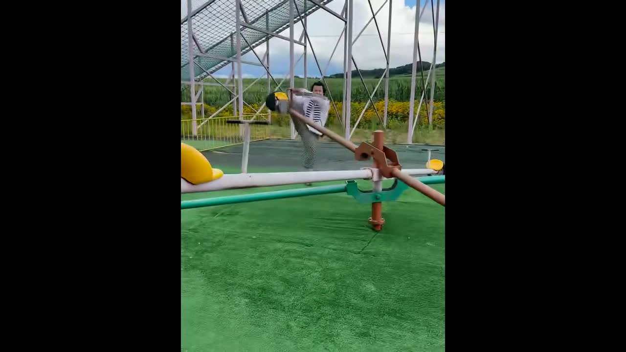 Man struggles to balance on rotating seesaw in Jilin, China