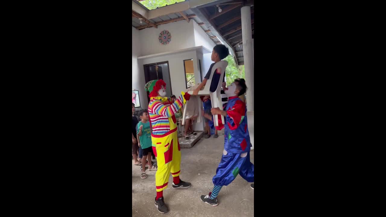 Acrobat clown stuns crowd by balancing chair with youngster